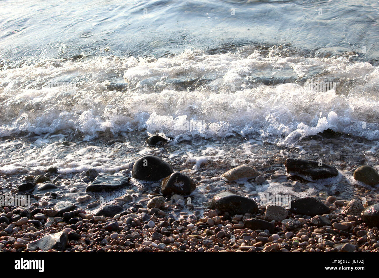 Pebbles on the beach with wave Stock Photo - Alamy