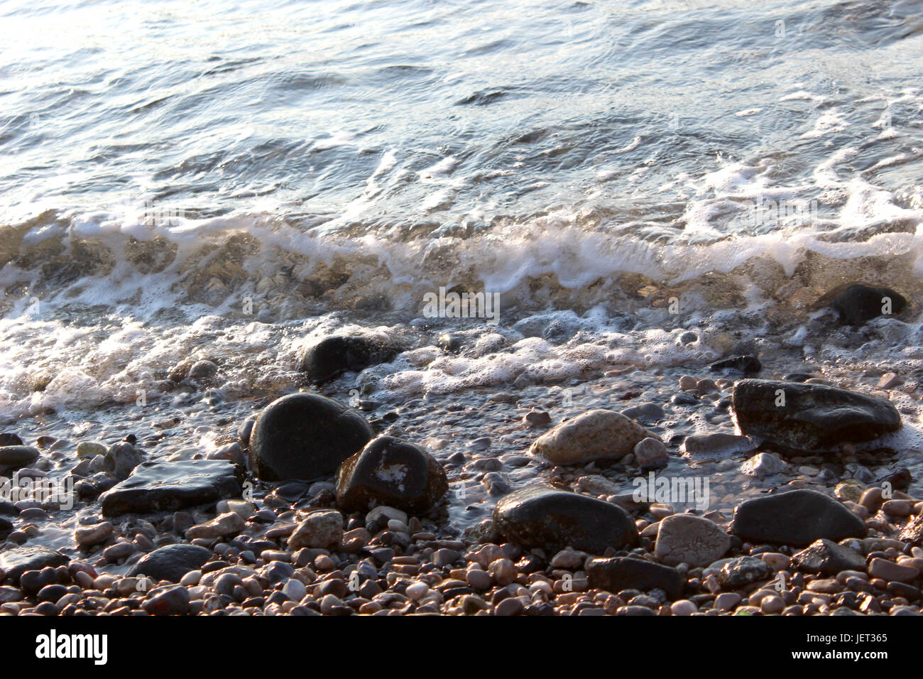 Pebbles on the beach with wave Stock Photo - Alamy