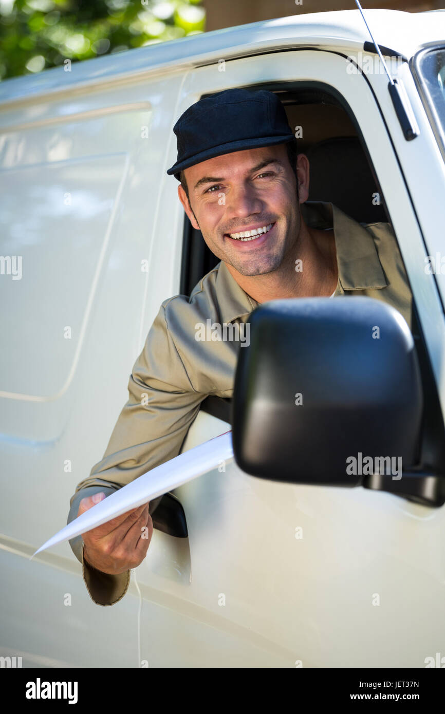 Smiling delivery man sitting in his van Stock Photo - Alamy