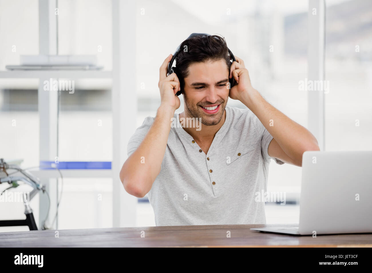 Young man using headphones and laptop Stock Photo - Alamy