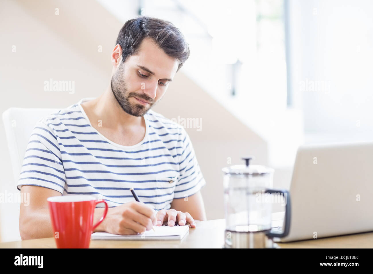 Man writing note on notepad Stock Photo - Alamy