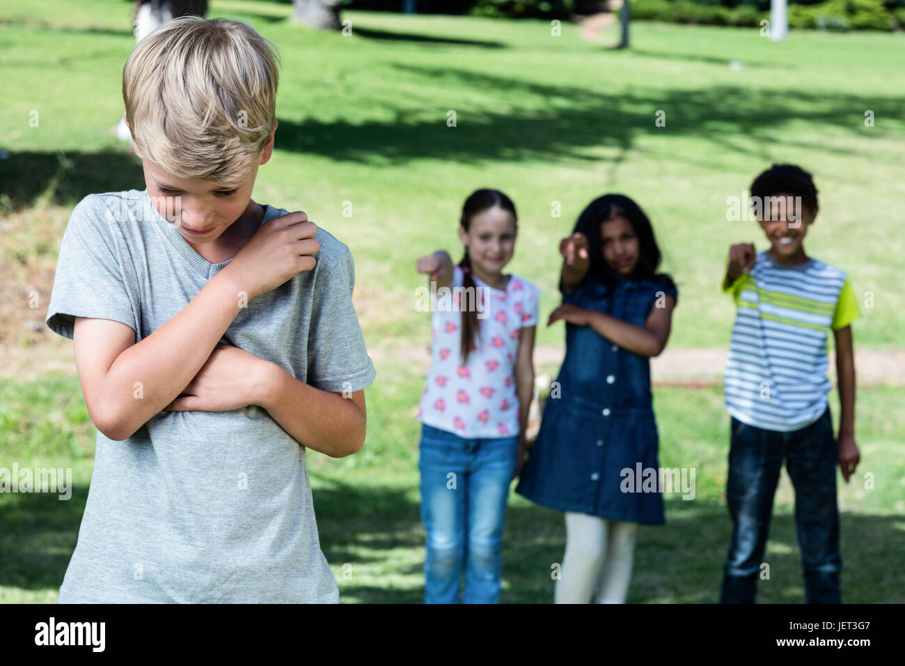 Friends teasing a boy Stock Photo - Alamy