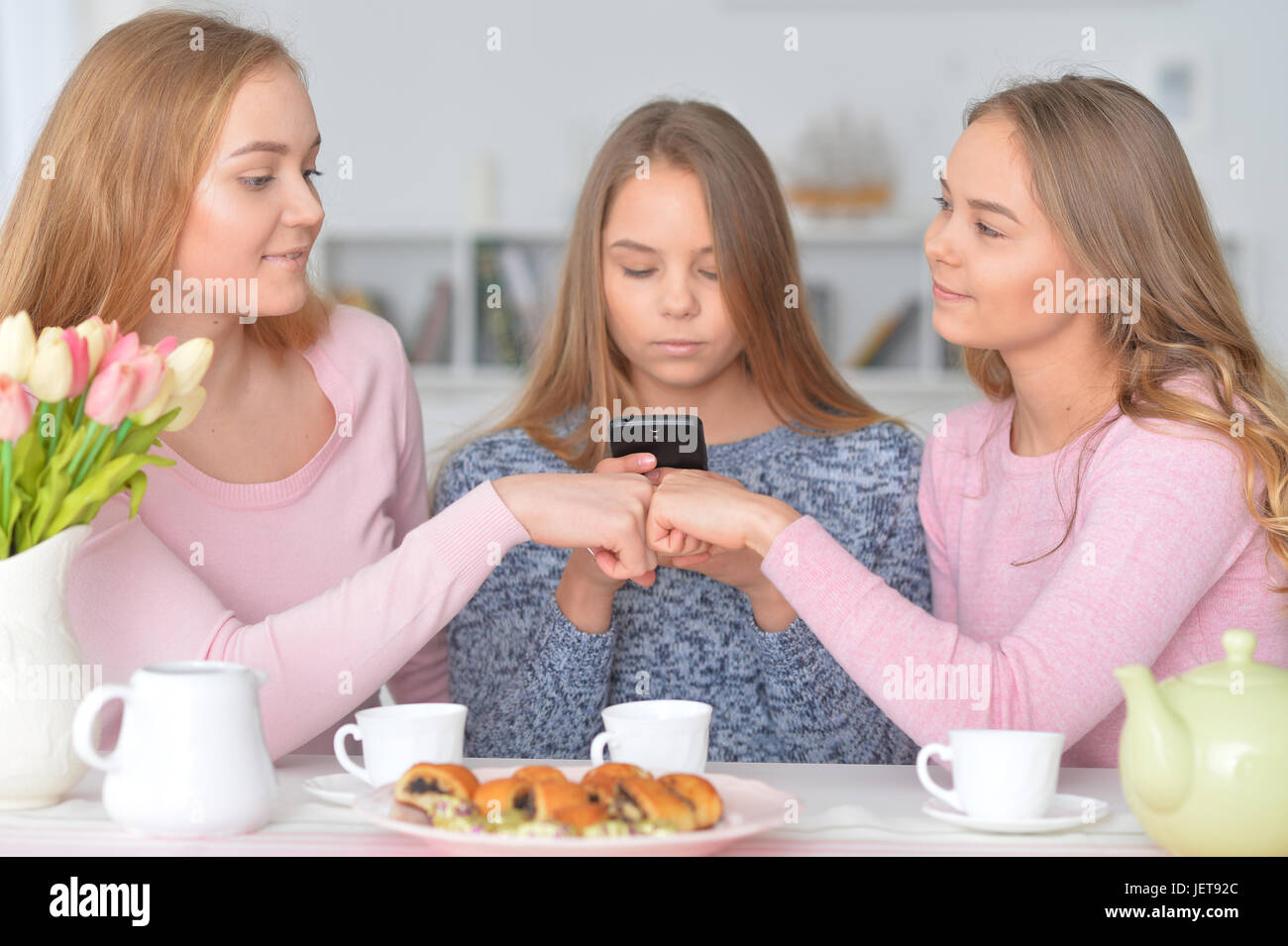 Group of teenage girls sitting at table with smartphone Stock Photo - Alamy