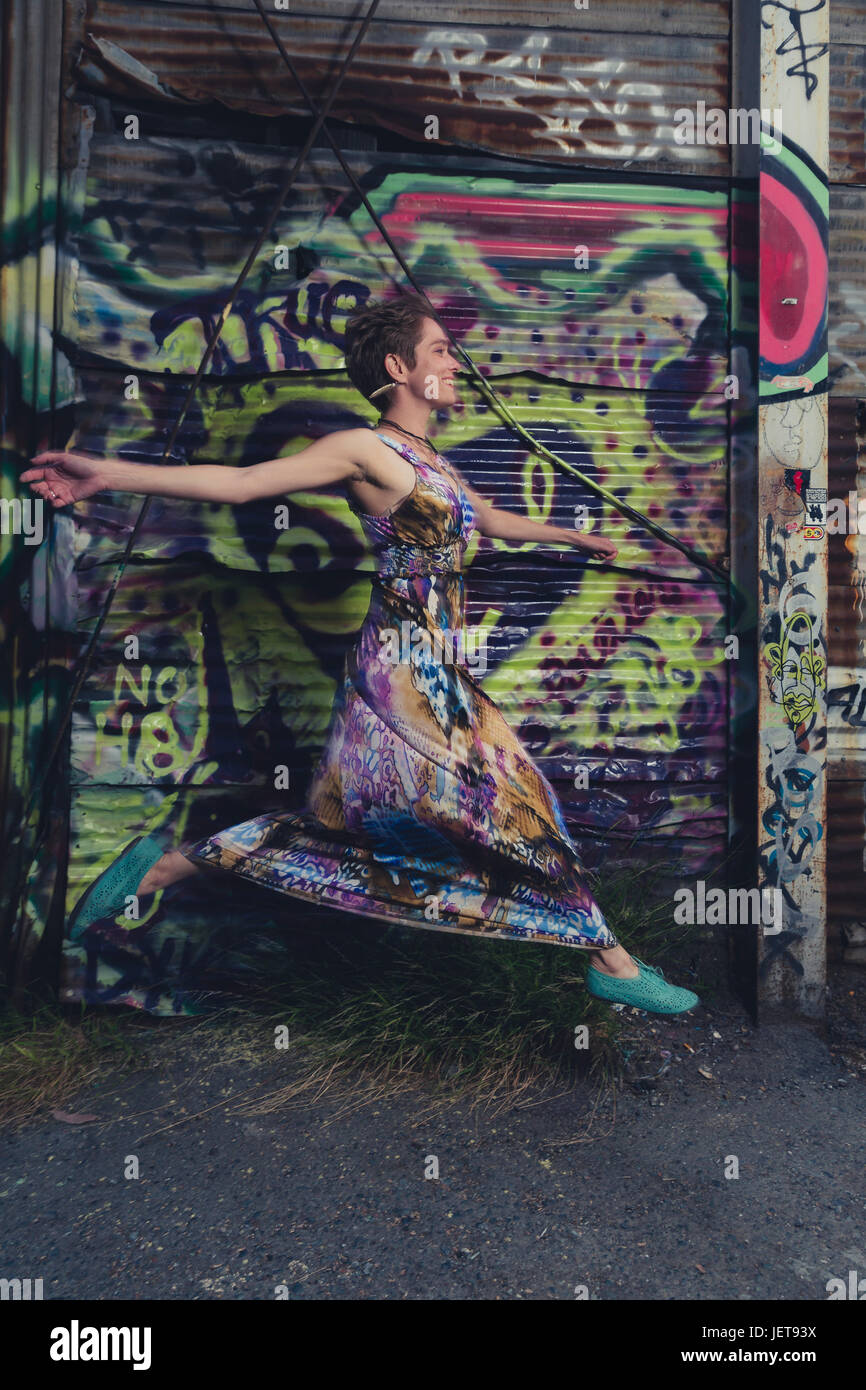 A young caucasian woman with androgynous features wears casual clothing ...
