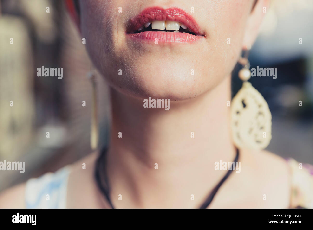 A young caucasian woman with androgynous features wears casual clothing ...