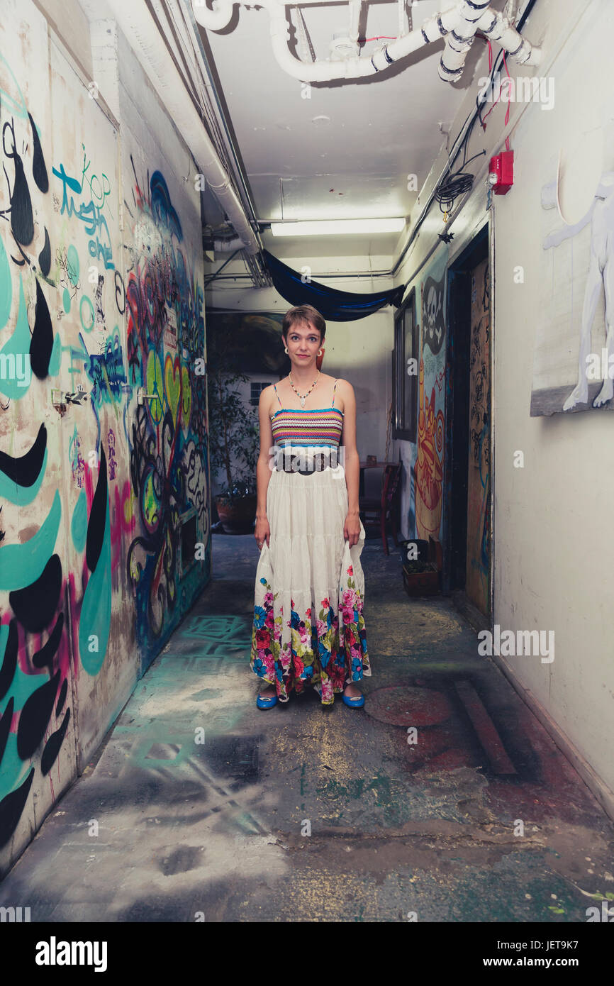 A young caucasian woman with androgynous features wears casual clothing ...