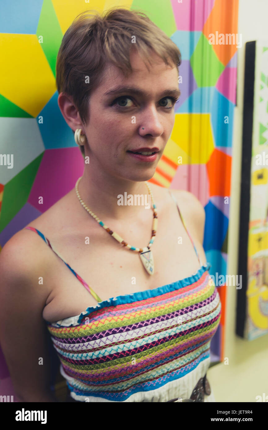 A young caucasian woman with androgynous features wears casual clothing ...