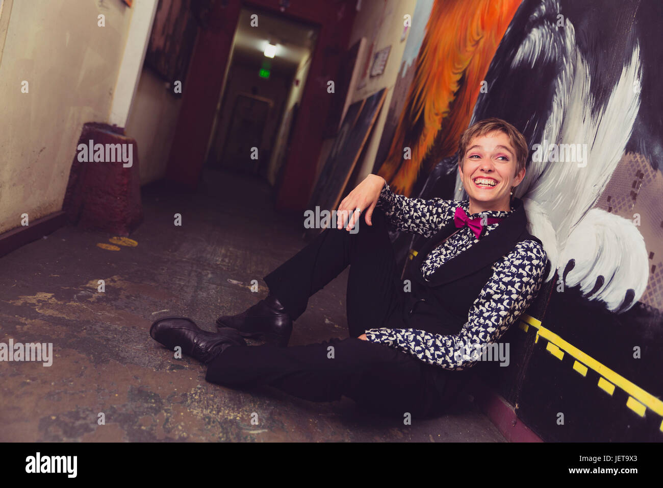 A young caucasian woman with androgynous features wears formal clothing ...