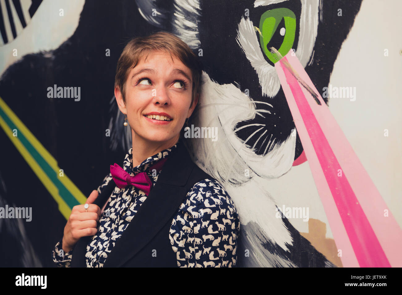 A young caucasian woman with androgynous features wears formal clothing ...
