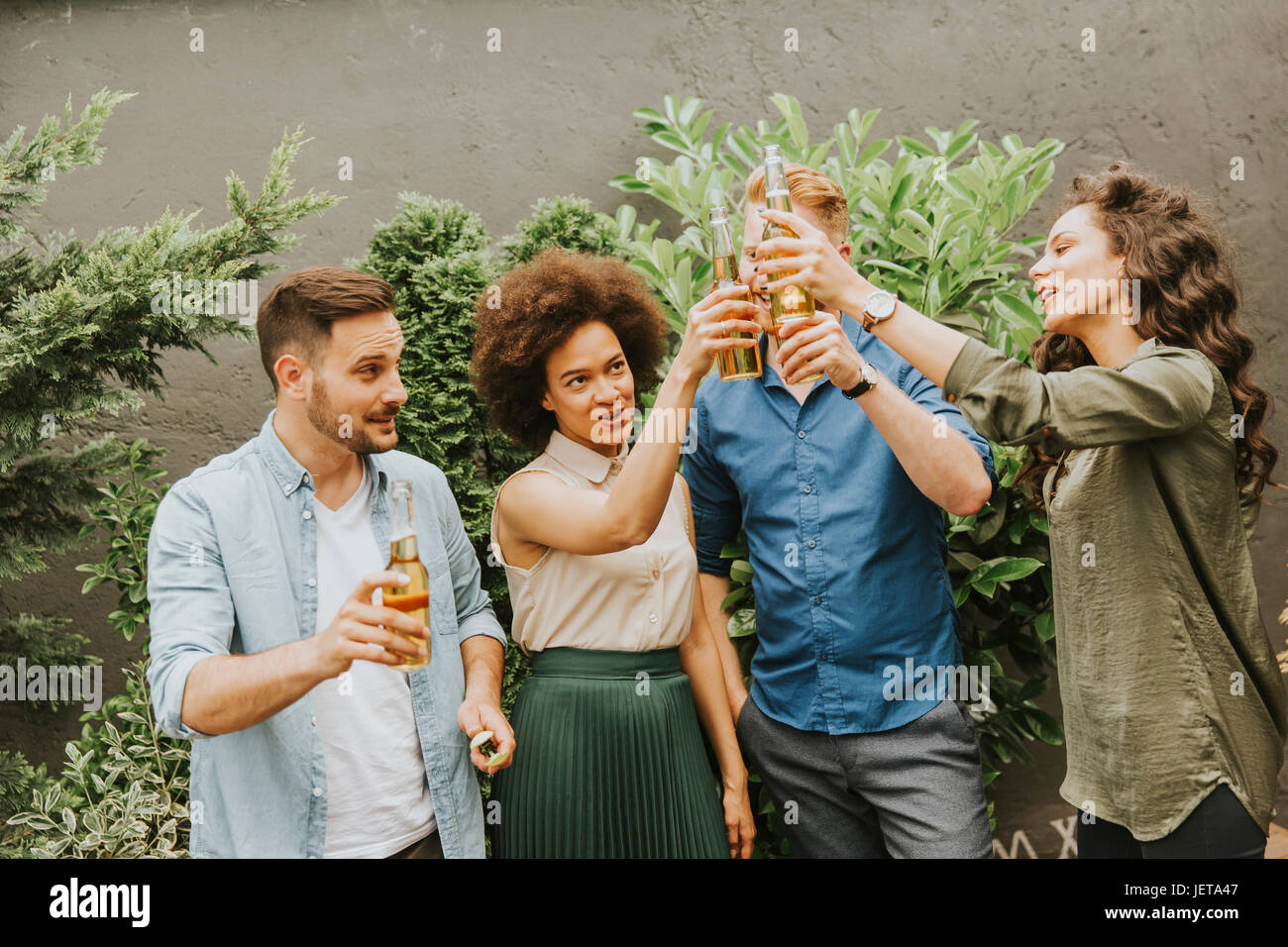 Group of friends having outdoor garden party toast with alcoholic cider ...