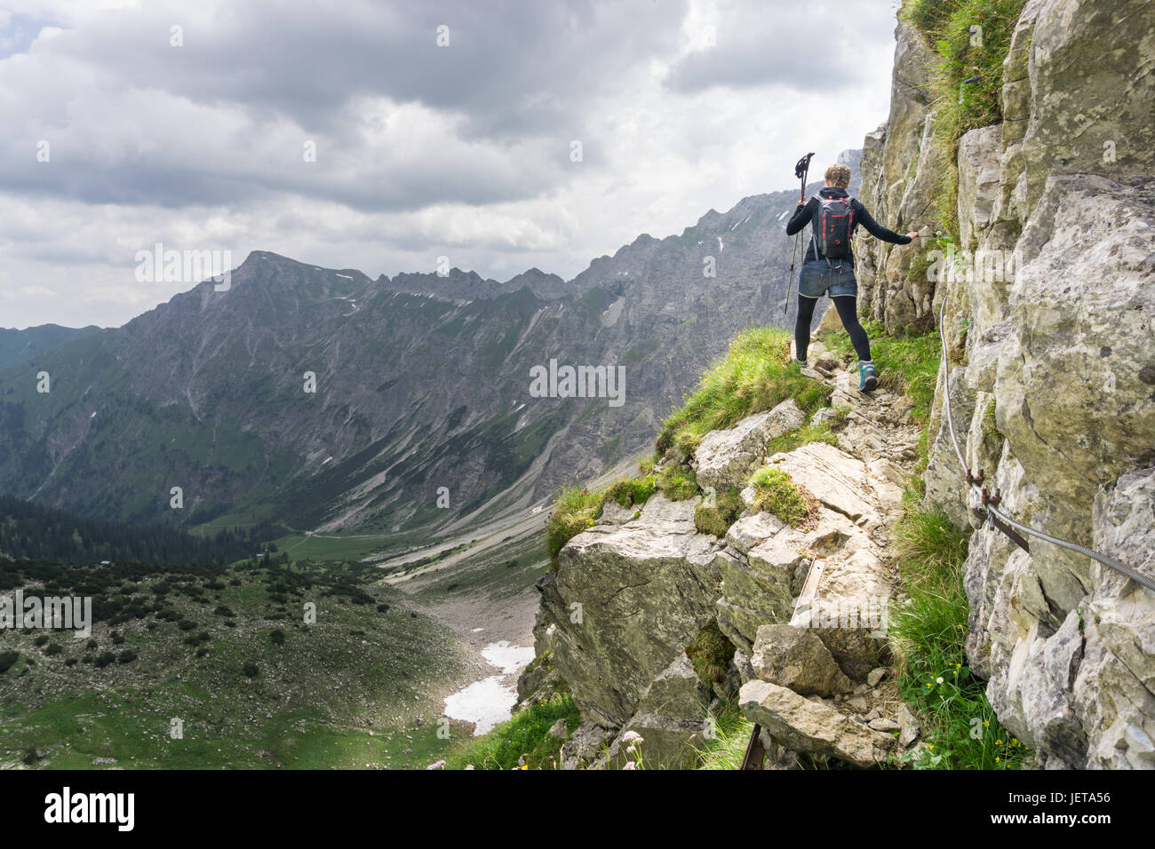 Woman walks on dangerous trail in alpine mountains Stock Photo - Alamy