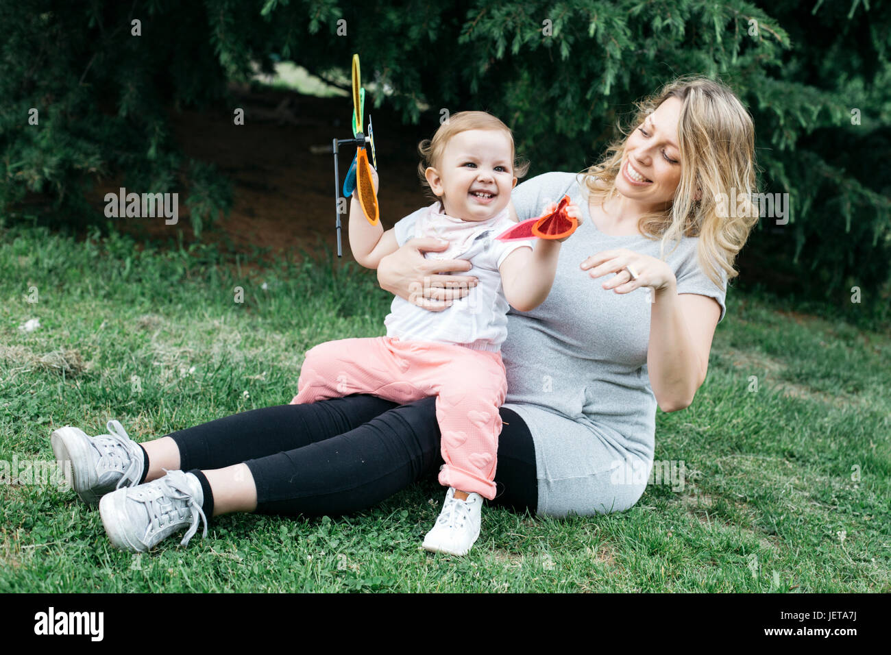 View at pregnant mother and little girl on grass Stock Photo - Alamy