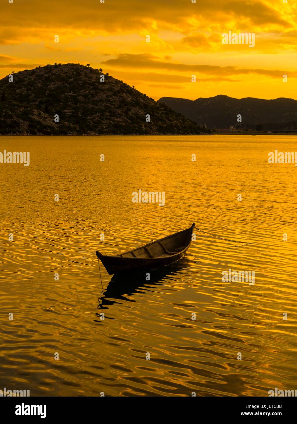 One lonely boat on golden-glowing sea in Rogotin in Croatia Stock Photo ...