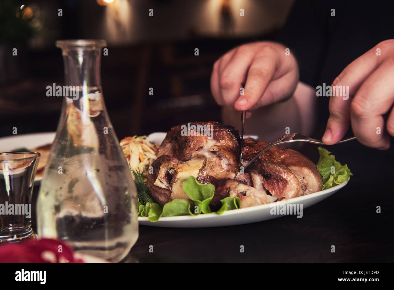 Man eats tasty dish of pork shank Stock Photo - Alamy