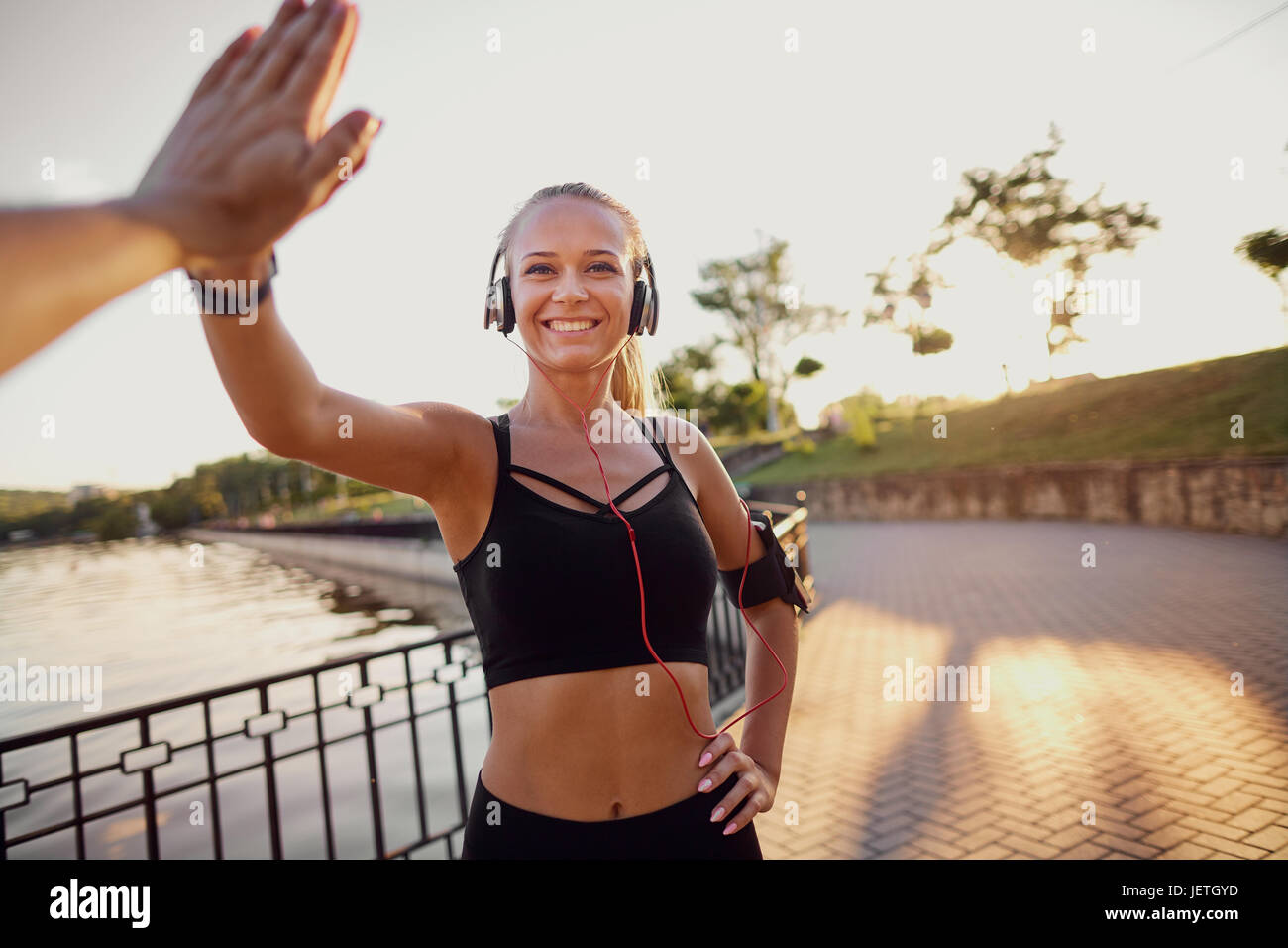 Runner girl giving high five in the park Stock Photo - Alamy