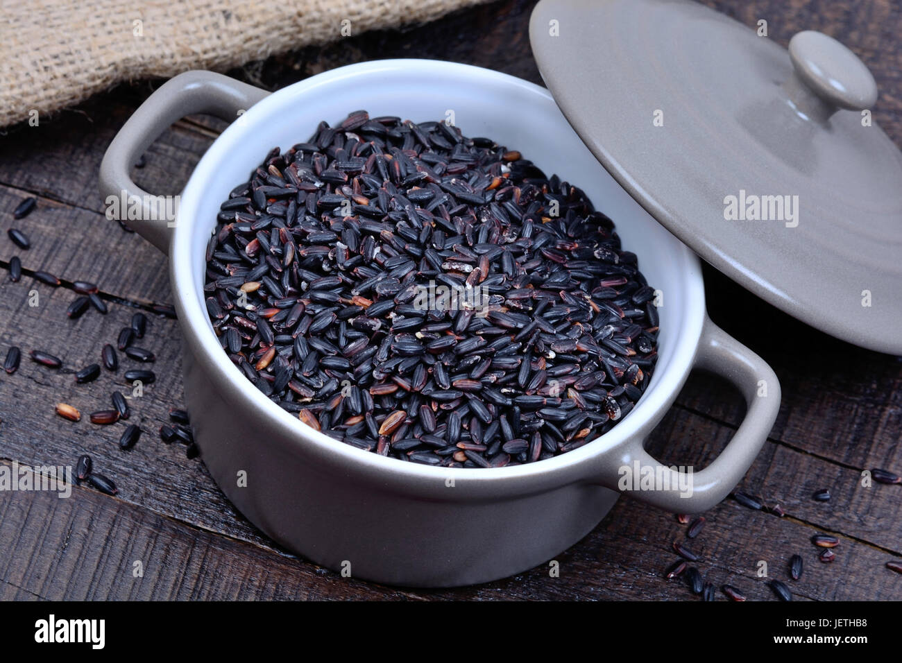Black rice in a pot on wooden table Stock Photo - Alamy
