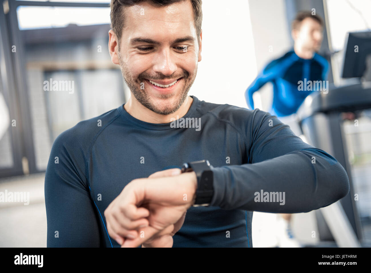Handsome young man using smartwatch at gym Stock Photo - Alamy