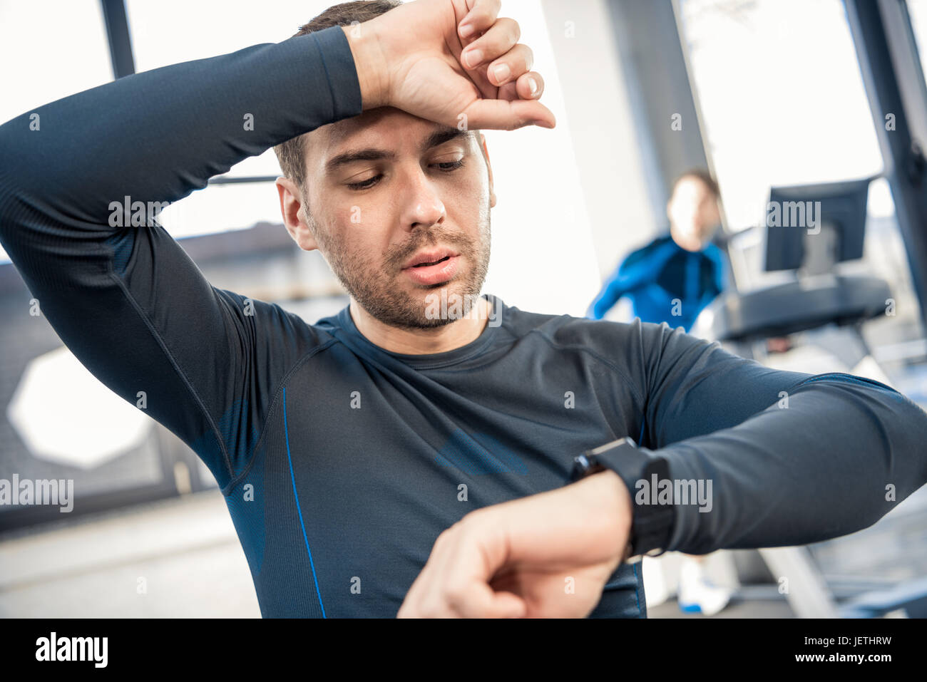 Handsome young man using smartwatch at gym Stock Photo - Alamy