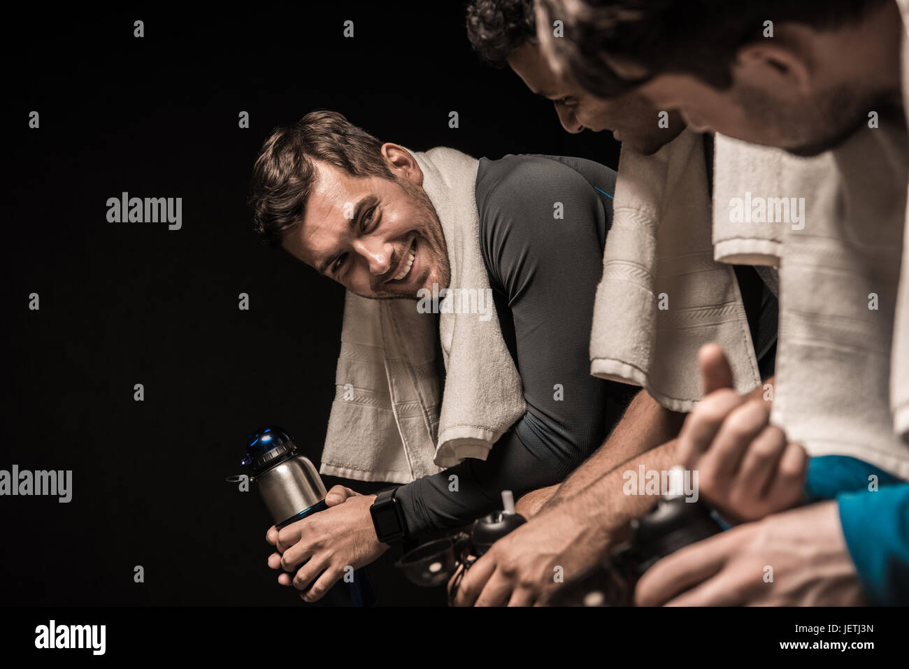 Handsome young athletes resting at gym locker room Stock Photo - Alamy