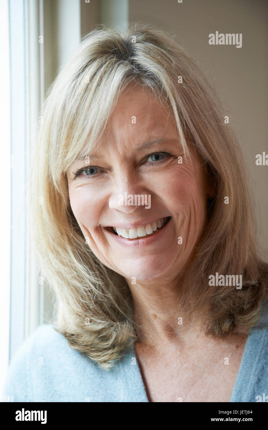 Smiling Mature Woman Standing Next To Window Stock Photo - Alamy