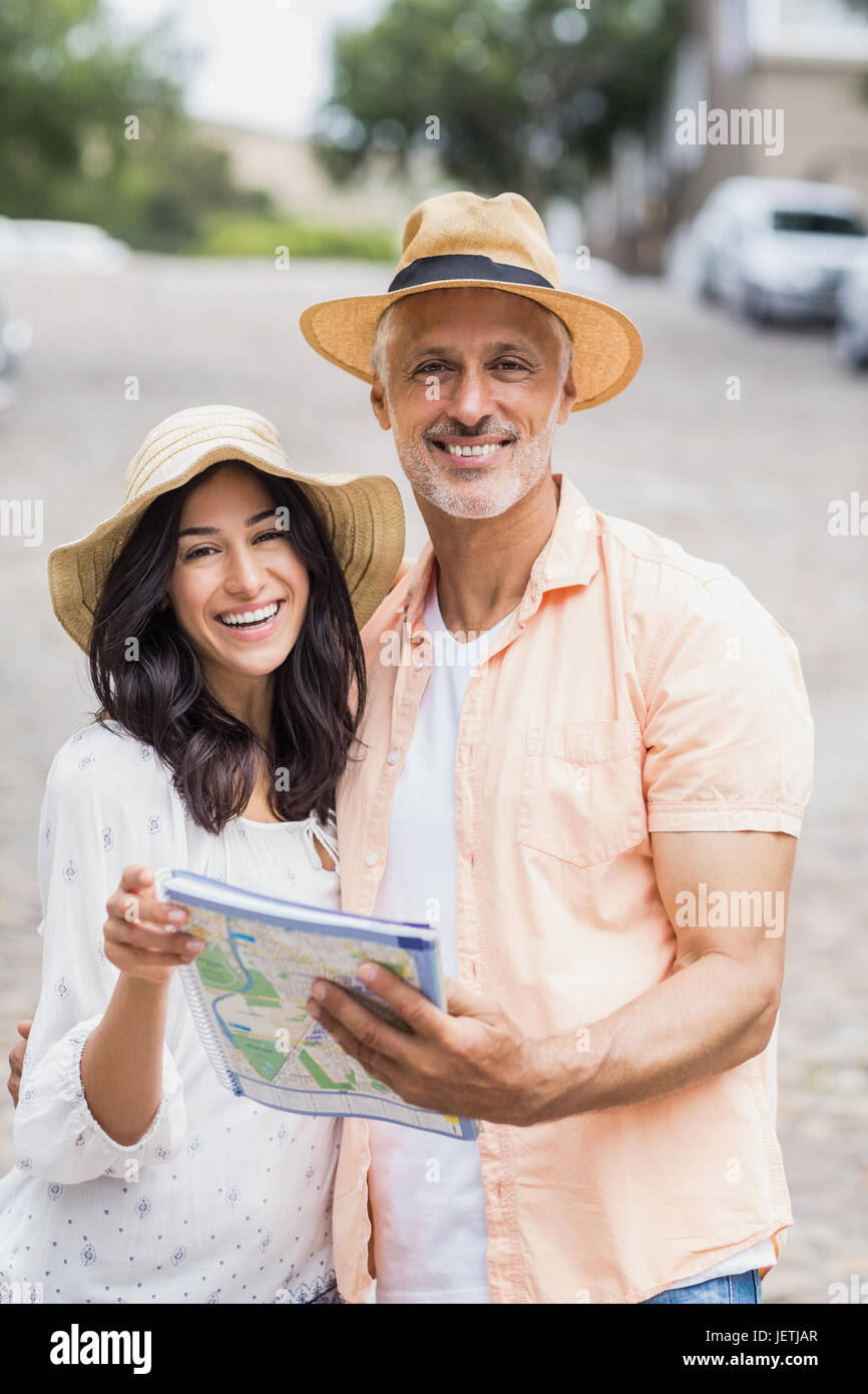 Couple holding map while standing on street Stock Photo - Alamy