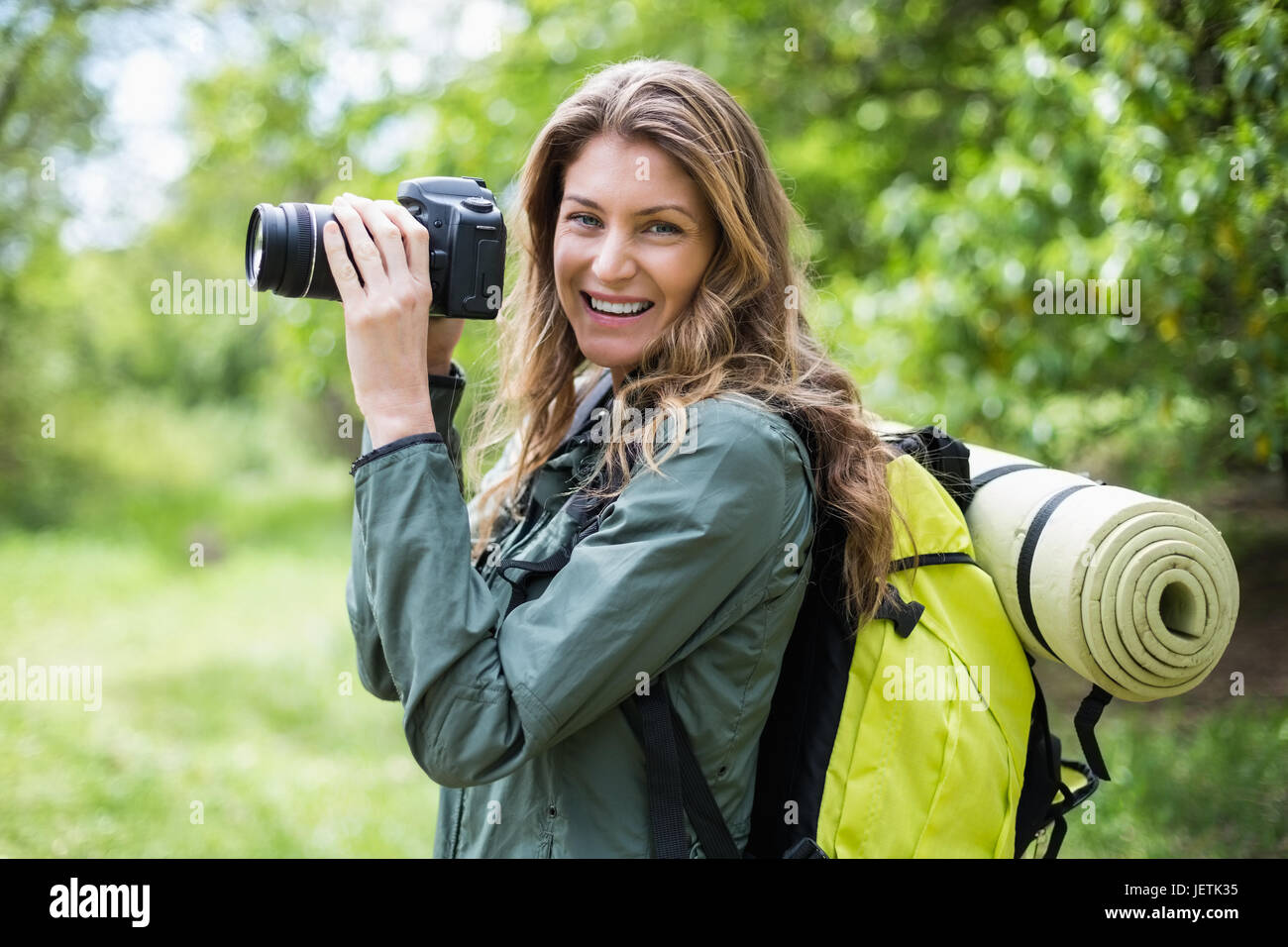 Portrait of smiling woman with camera Stock Photo - Alamy