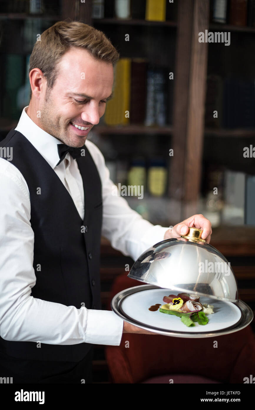 Handsome waiter serving meal Stock Photo - Alamy