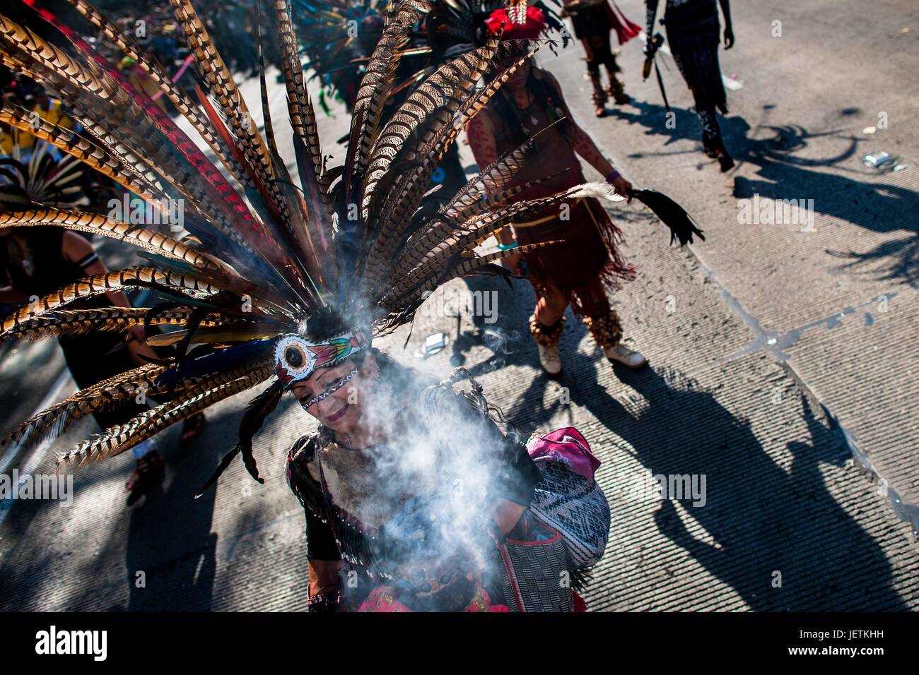 A Mexican woman, wearing a large feather headgear, performs an ancient ...