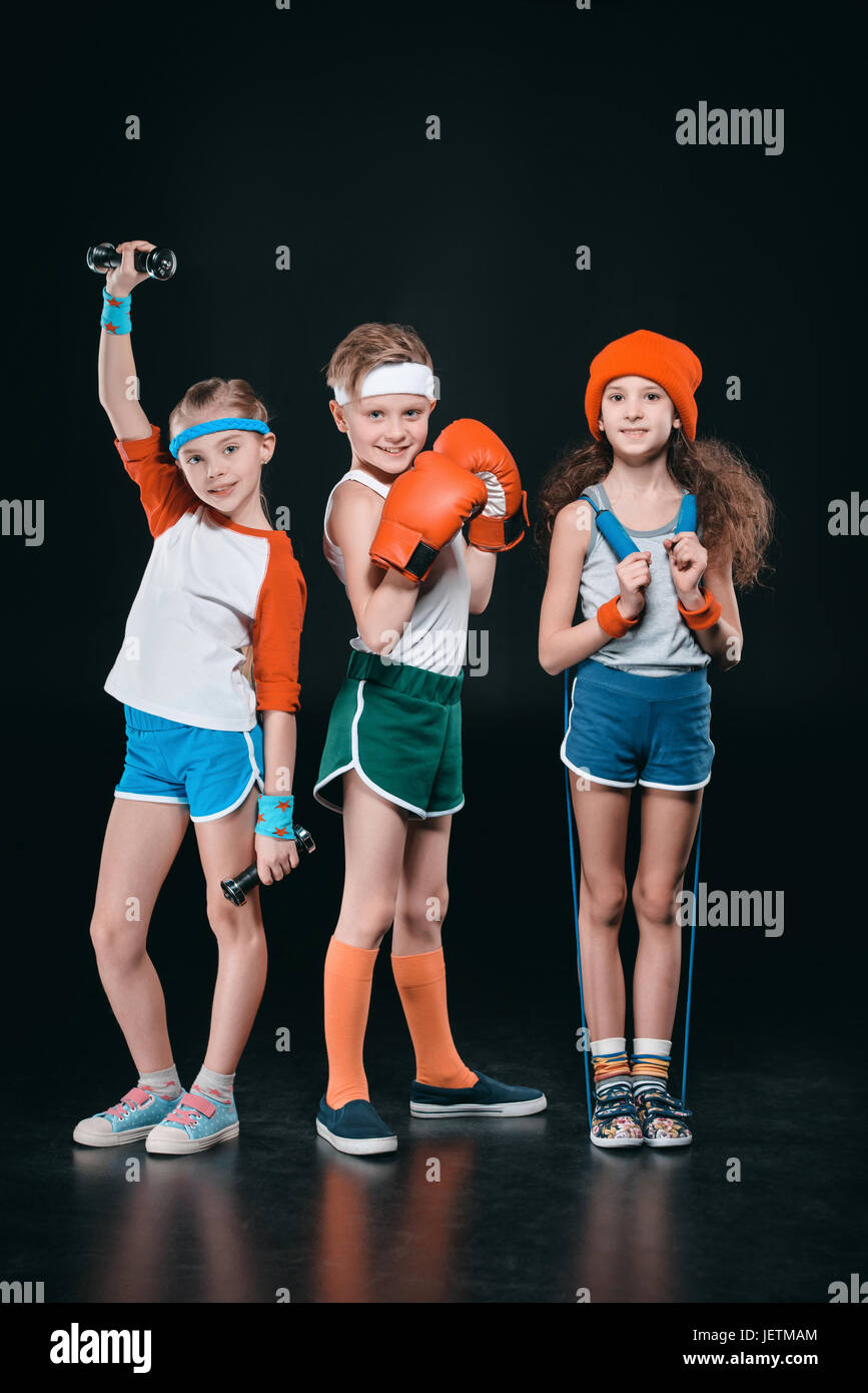Three active kids in sportswear posing with sport equipment isolated on ...