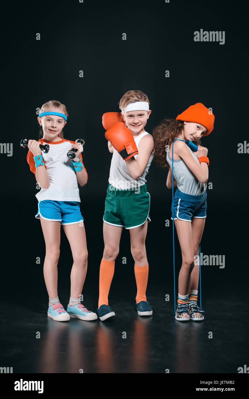 Three active kids in sportswear posing with sport equipment isolated on ...
