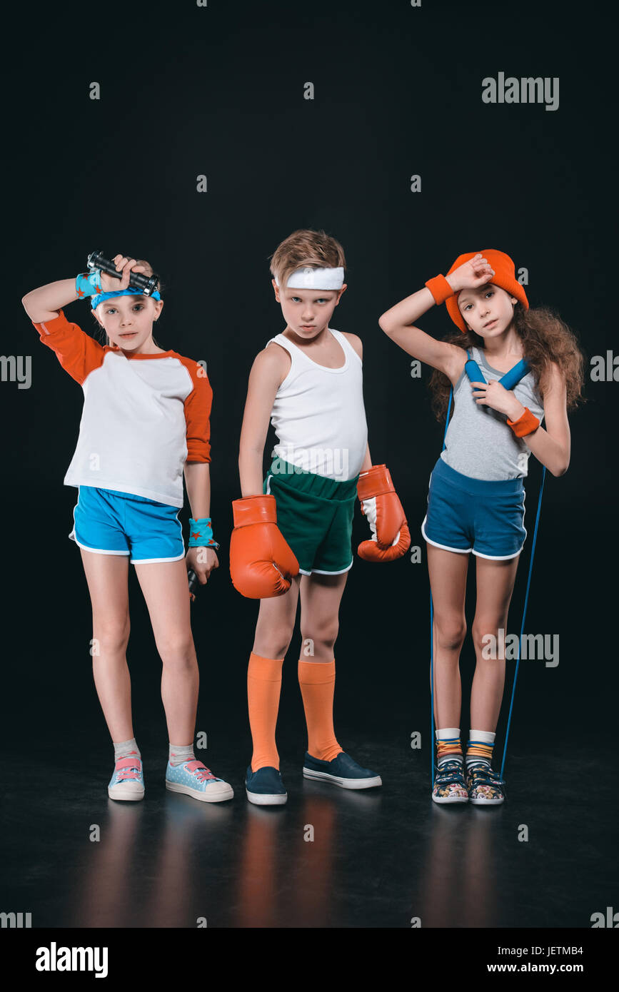 Three active kids in sportswear posing with sport equipment isolated on ...