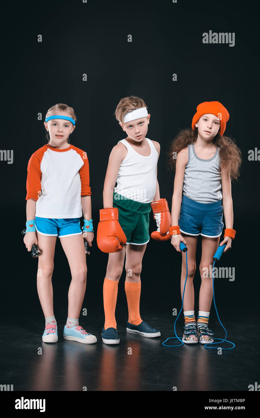 Three active kids in sportswear posing with sport equipment isolated on ...