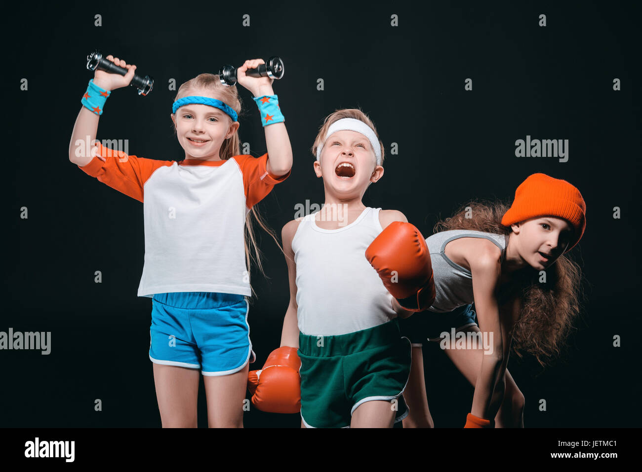 Three active kids in sportswear posing with sport equipment isolated on ...
