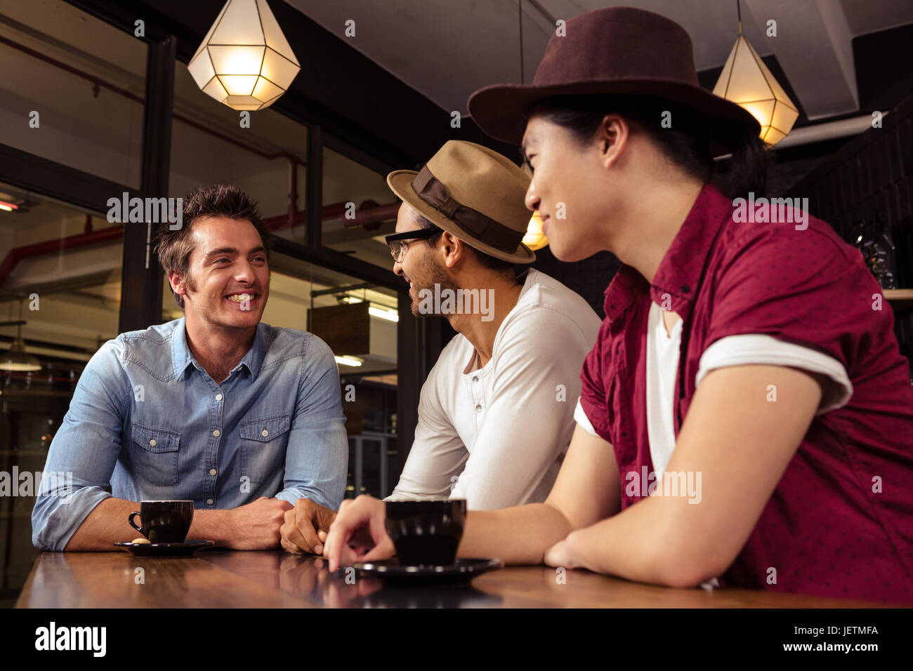 Friends sitting at a table Stock Photo - Alamy