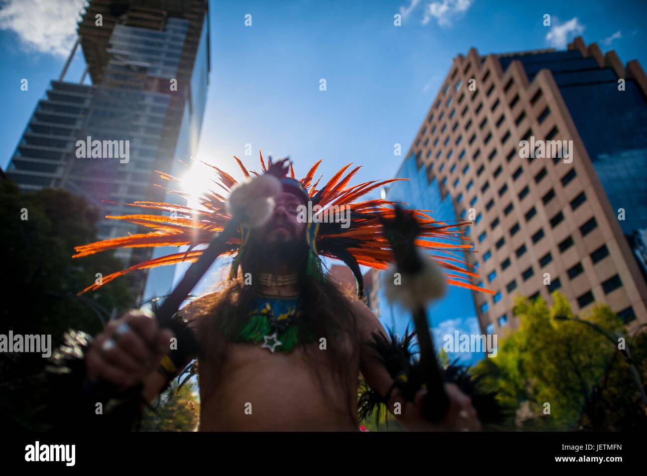 A Mexican man, wearing a colorful feather headgear inspired by Aztecs ...