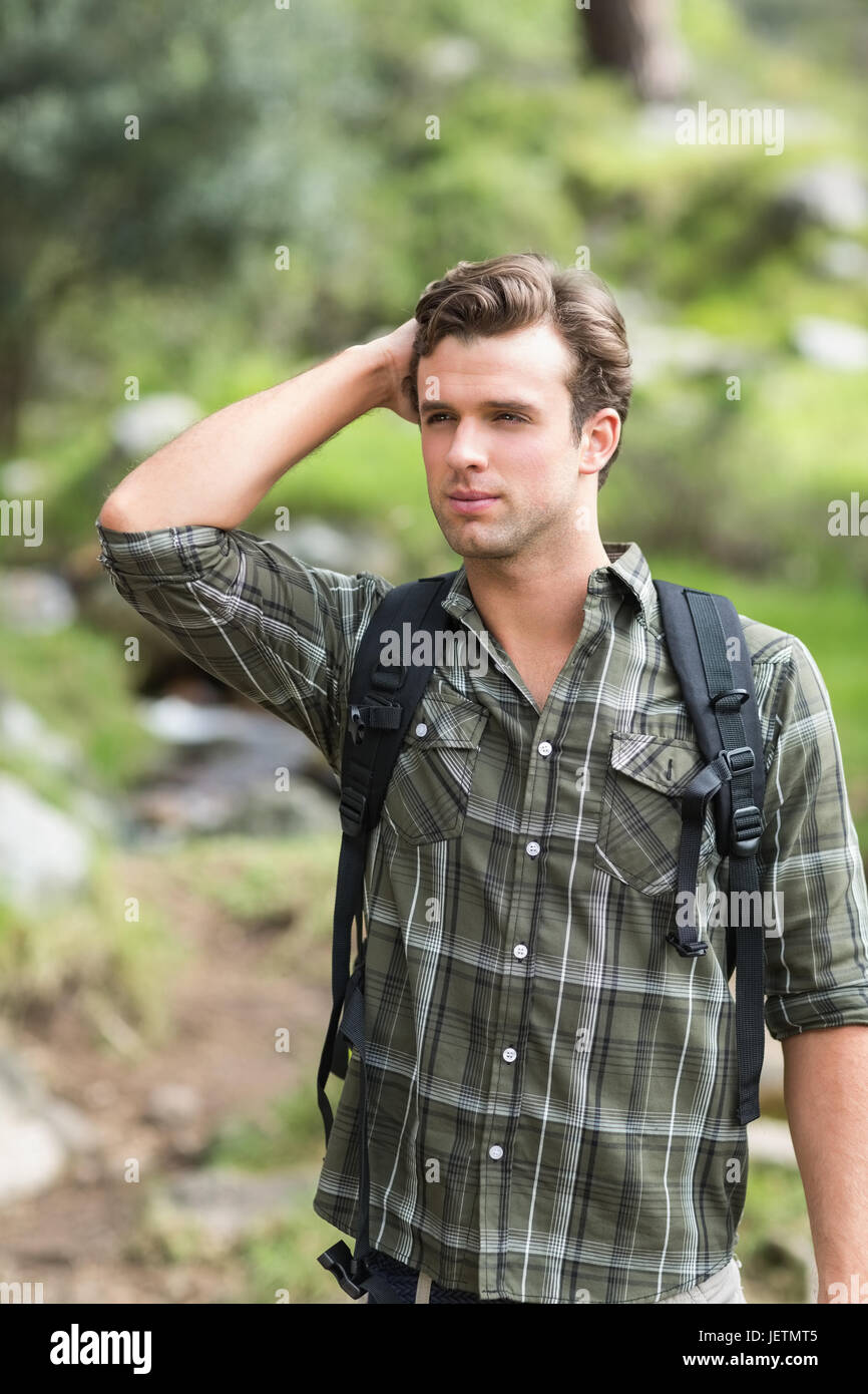 Handsome hiker looking away at forest Stock Photo - Alamy