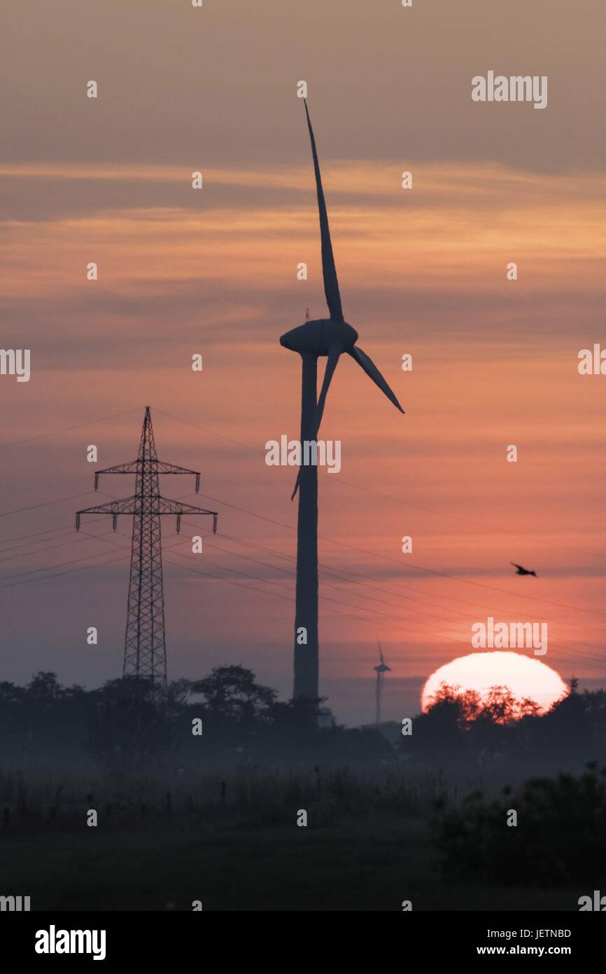 high-voltage transmission mast and windmill at sunrise, may 2017 ...