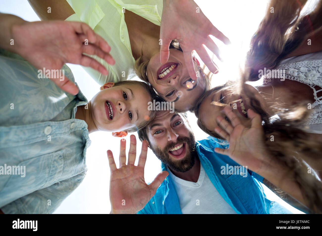 Family gesturing and forming huddle in yard Stock Photo - Alamy
