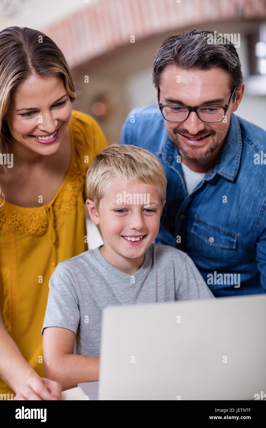 Parents and son using laptop in kitchen Stock Photo - Alamy