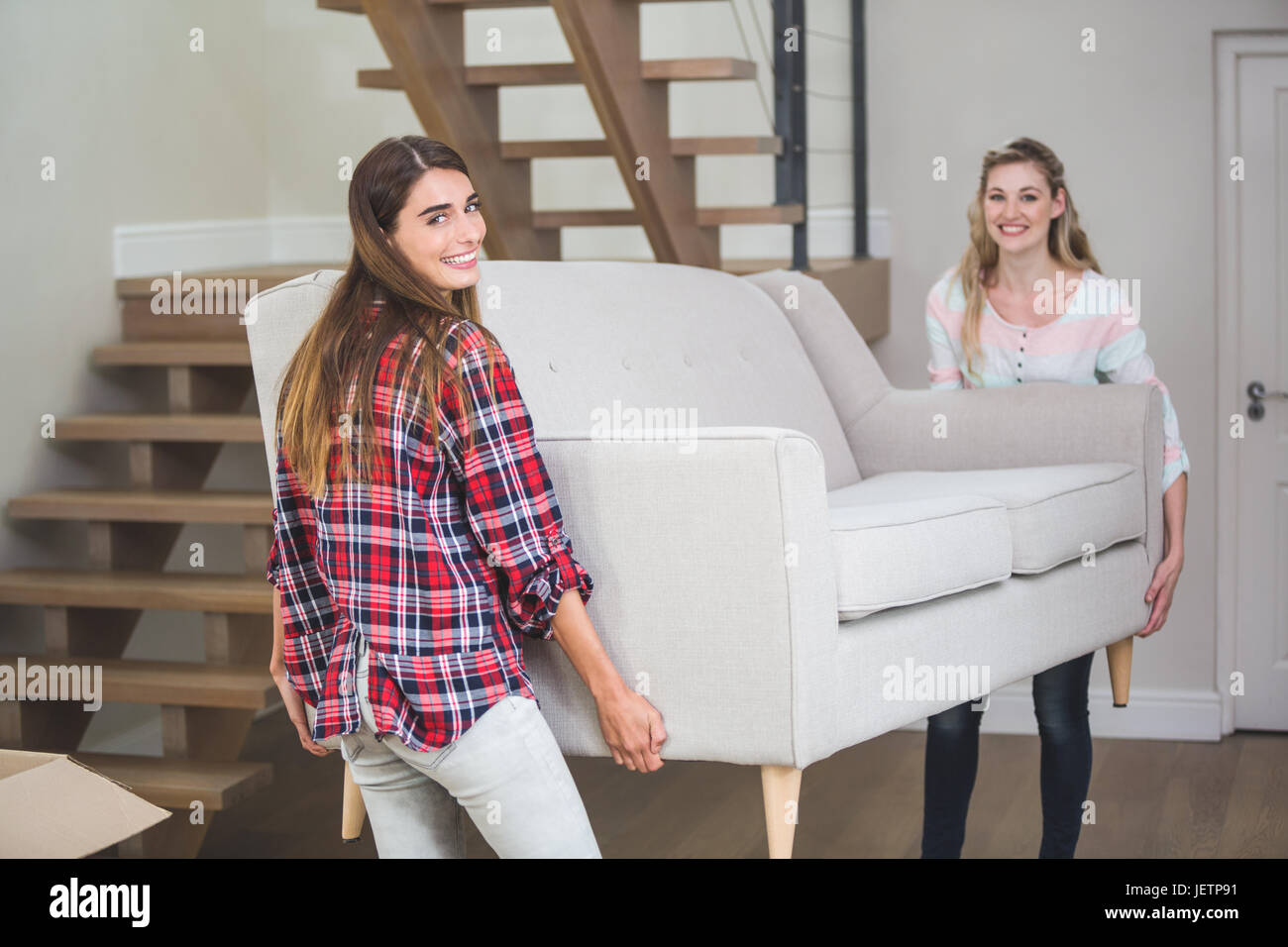 Friends shifting sofa in the new house Stock Photo - Alamy
