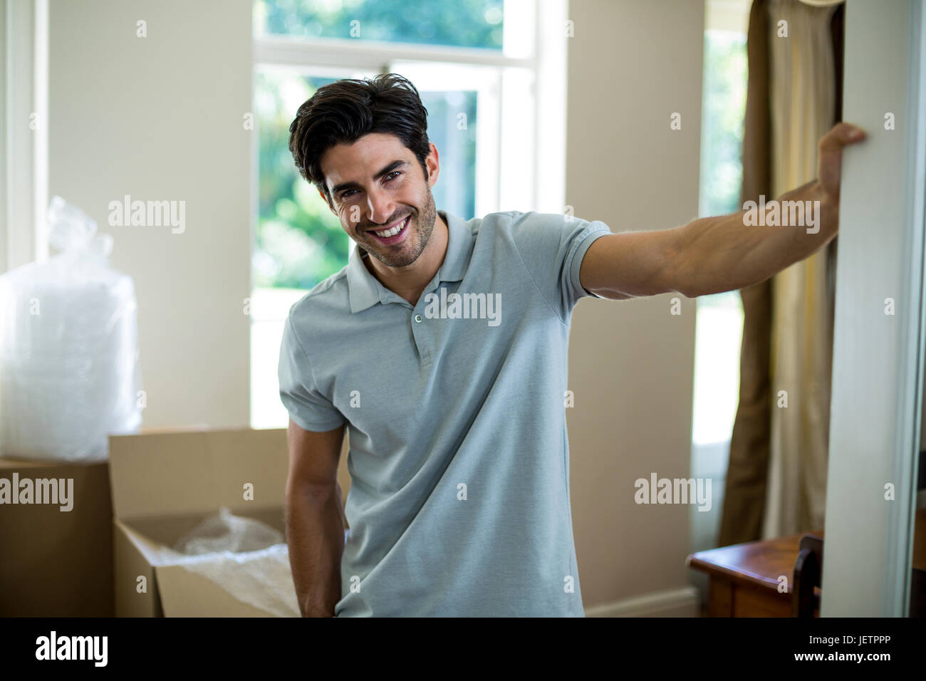 Young man standing in his new house Stock Photo - Alamy