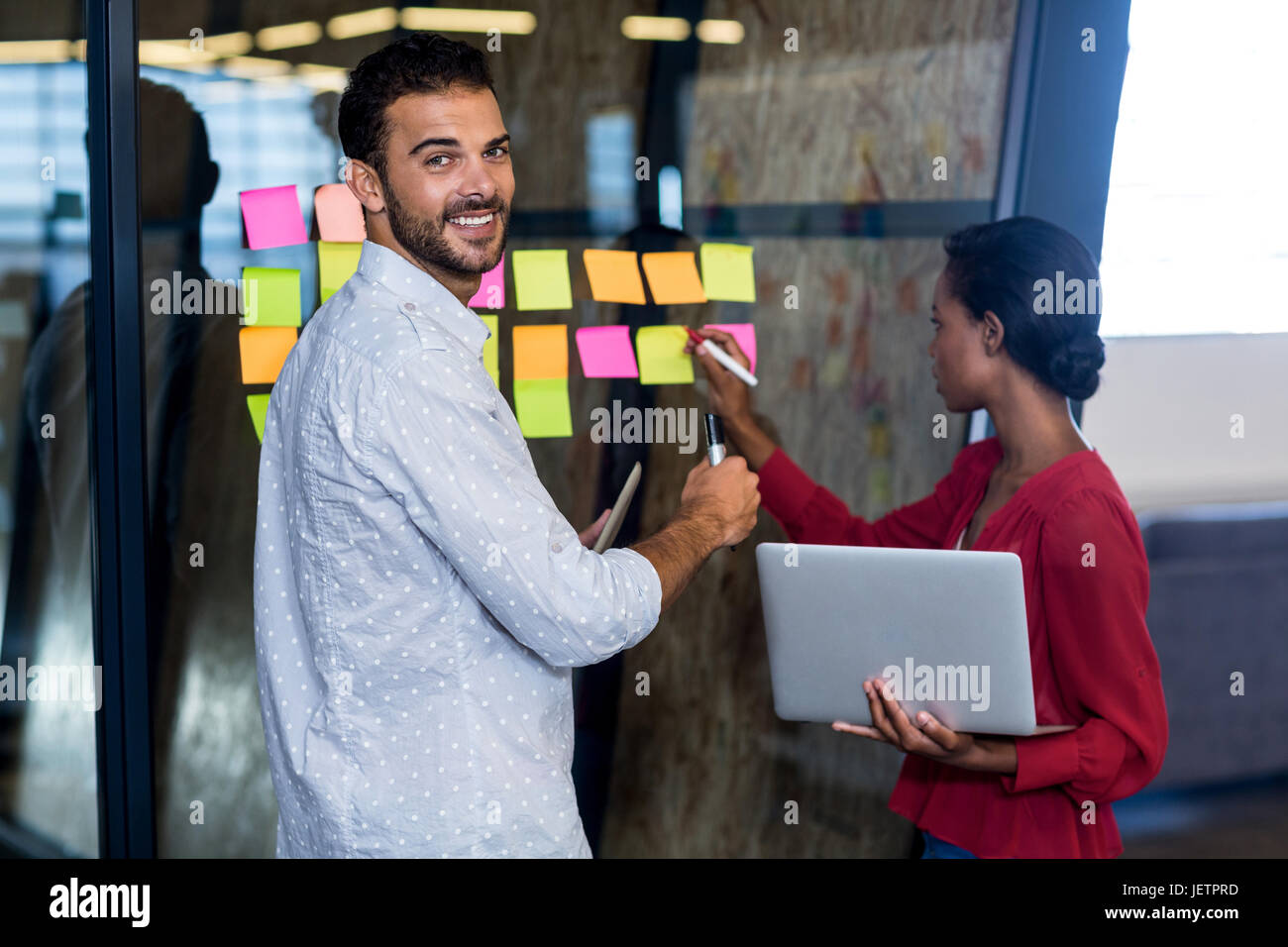 Colleagues writing on sticky notes Stock Photo - Alamy