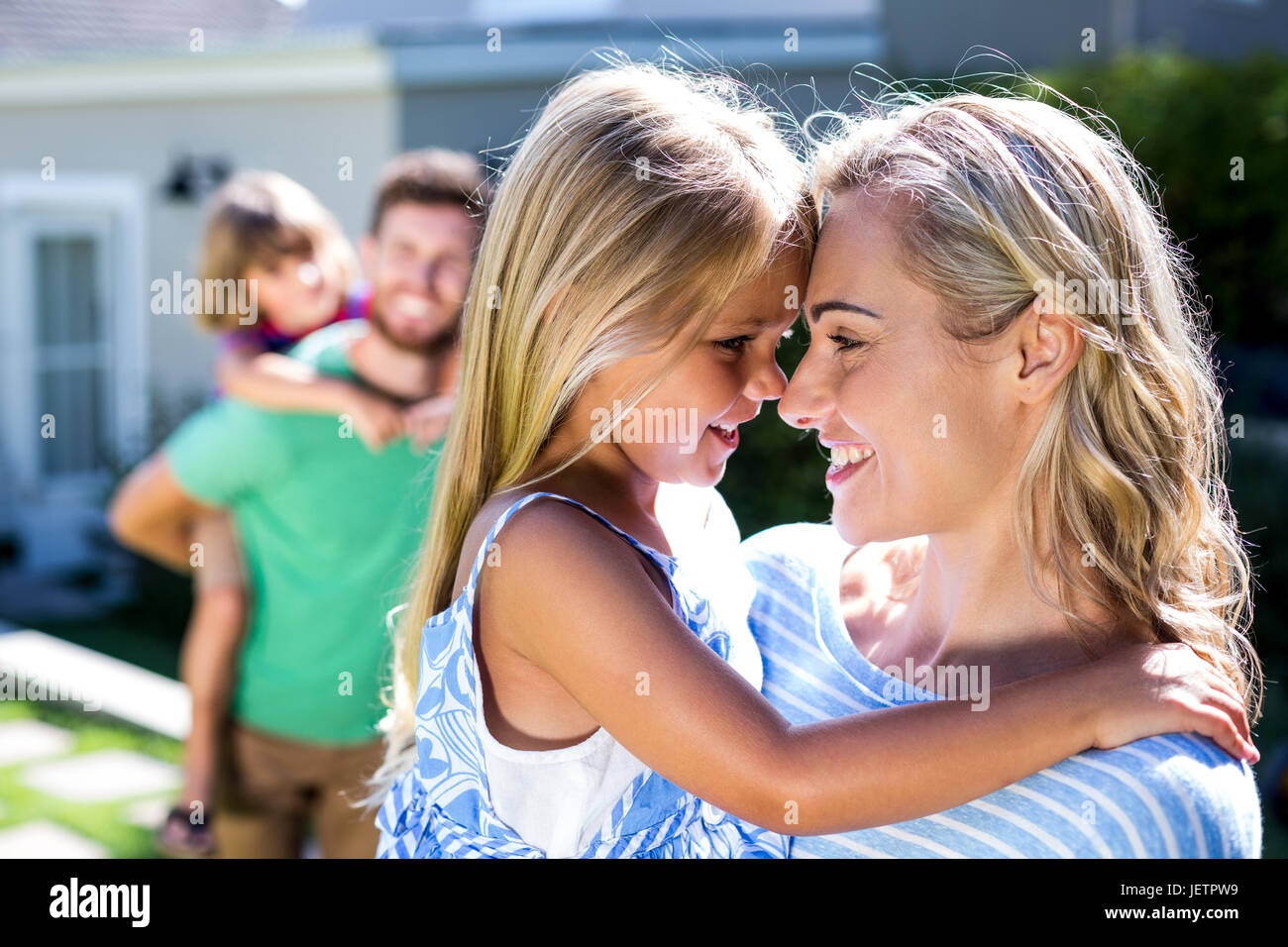 Parents carrying children in yard Stock Photo - Alamy