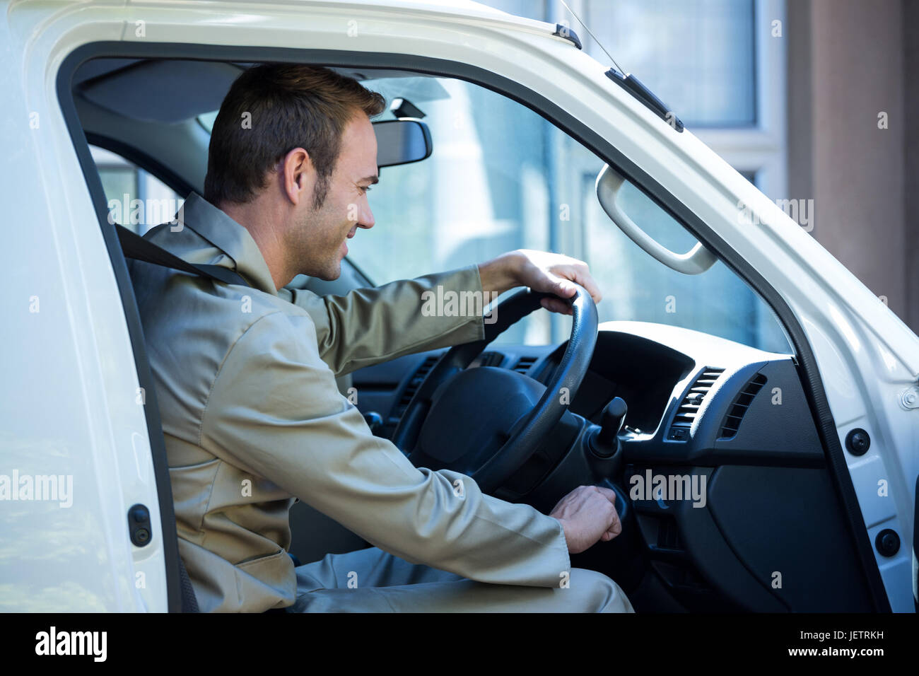 Delivery man starting a car Stock Photo - Alamy