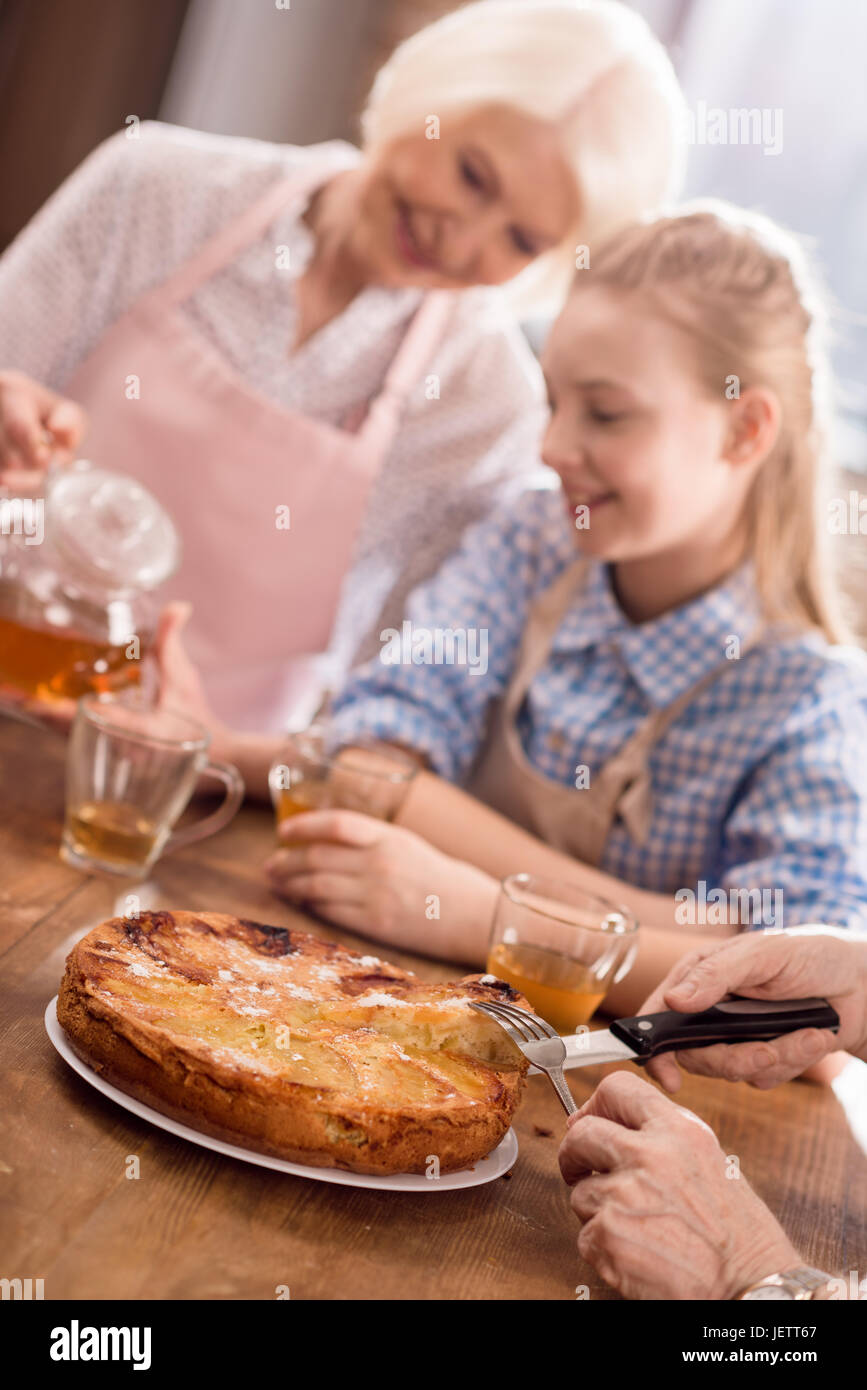 man cutting homemade pie while woman pouring tea Stock Photo - Alamy