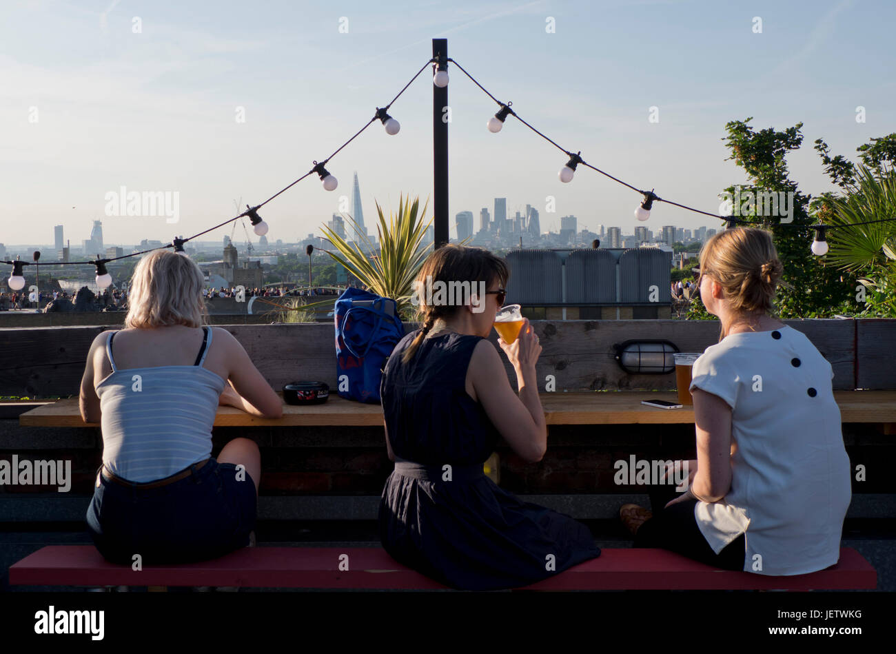 People enjoy a drink at a bar next to the pen air cinema at the rooftop ...
