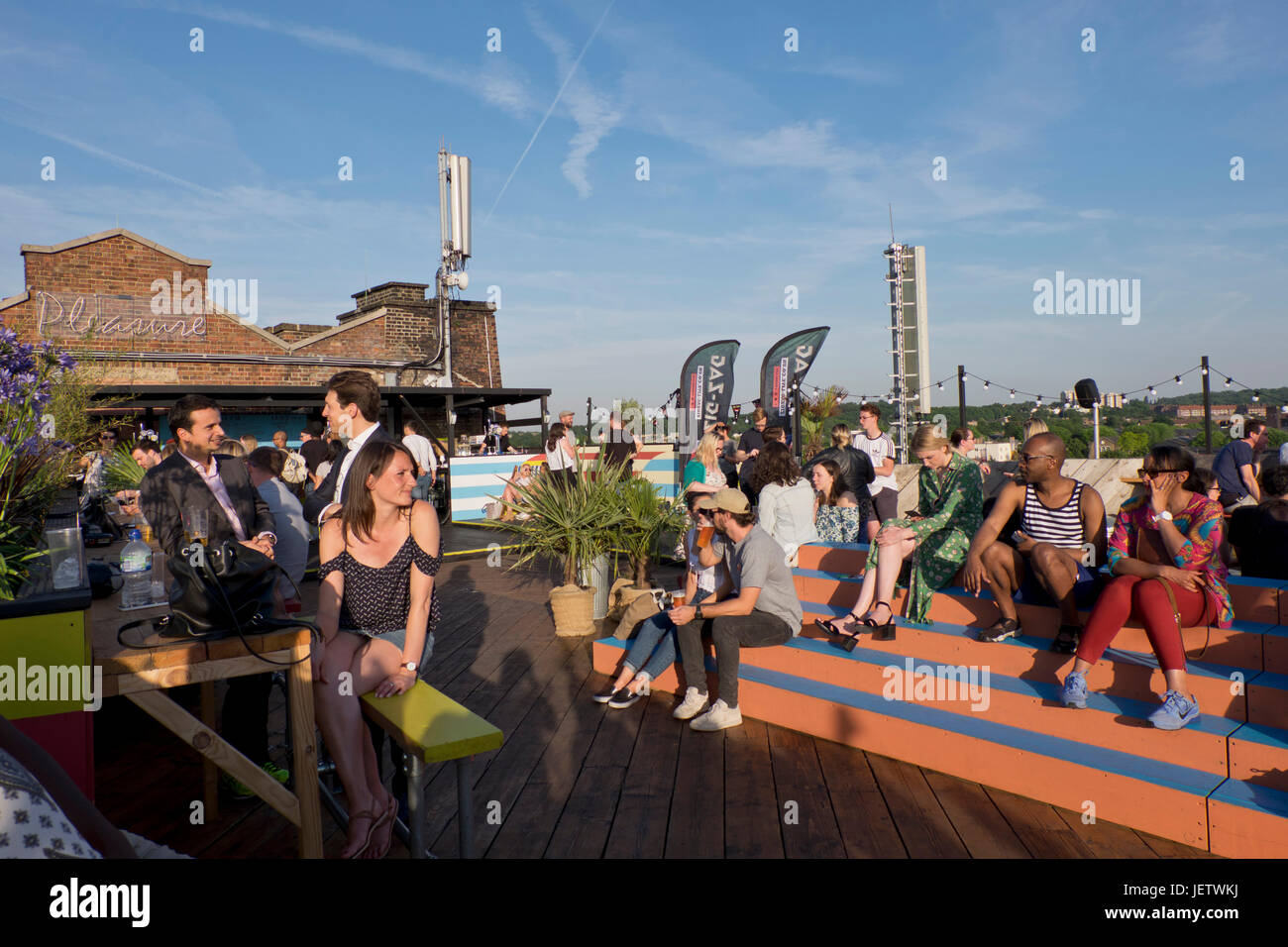People enjoy a drink at a bar next to the pen air cinema at the rooftop ...