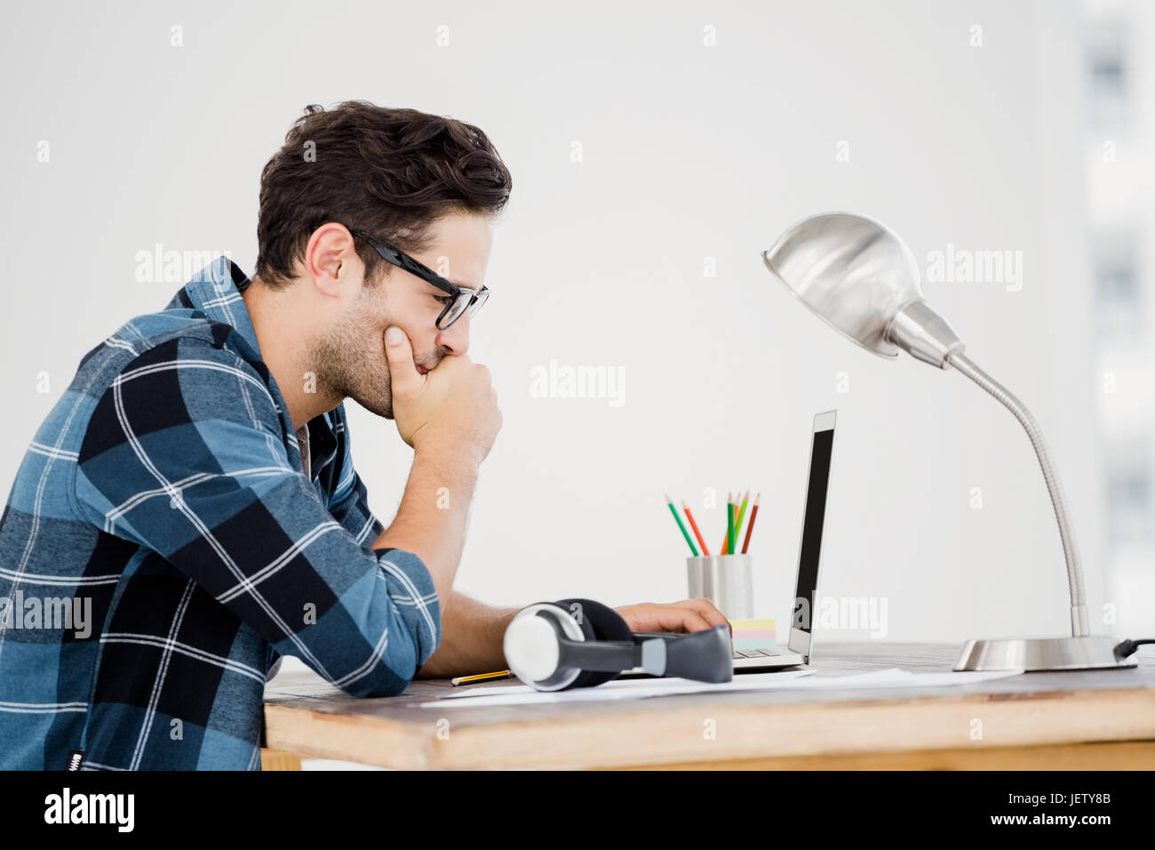 Young man working at his desk Stock Photo - Alamy