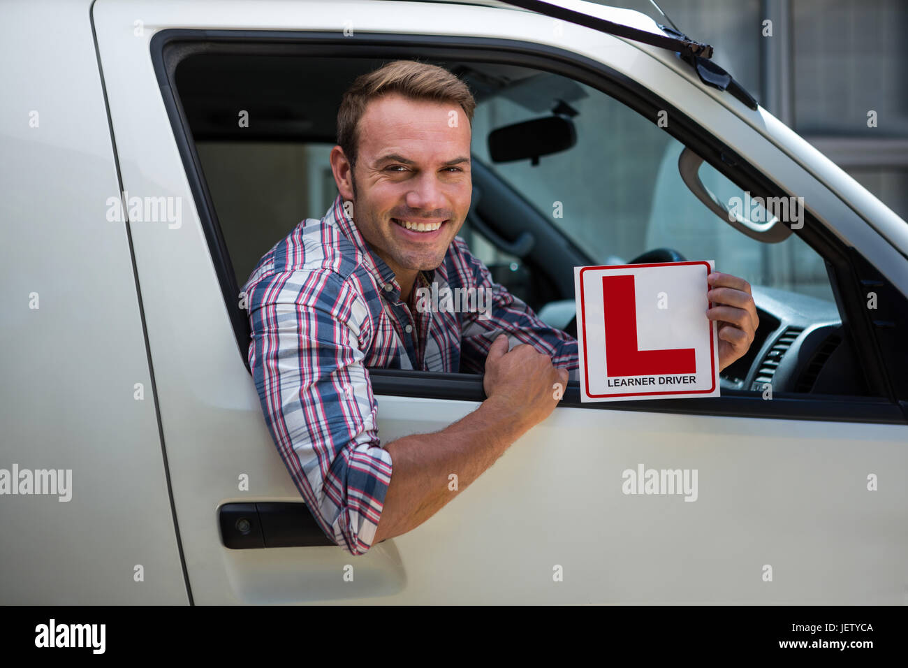 Young man holding a learner driver sign Stock Photo - Alamy