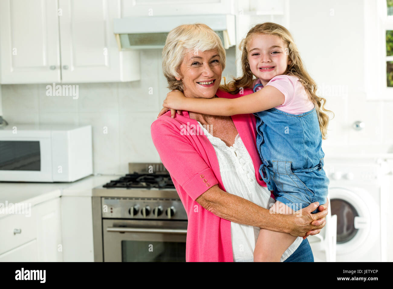Portrait of smiling granny carrying girl Stock Photo - Alamy